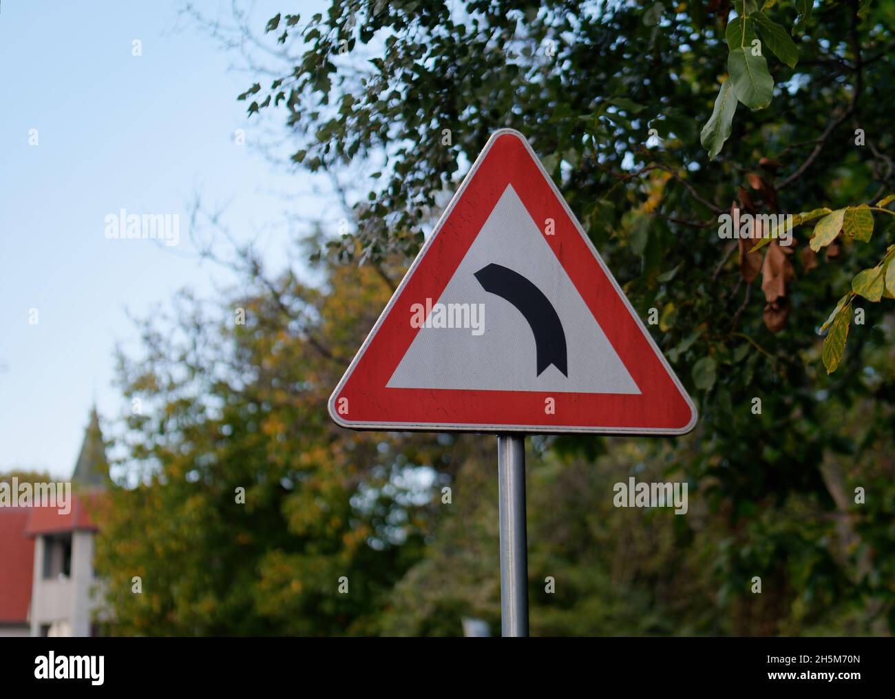 Red triangle warning sign about a dangerous curve to the left attached ...