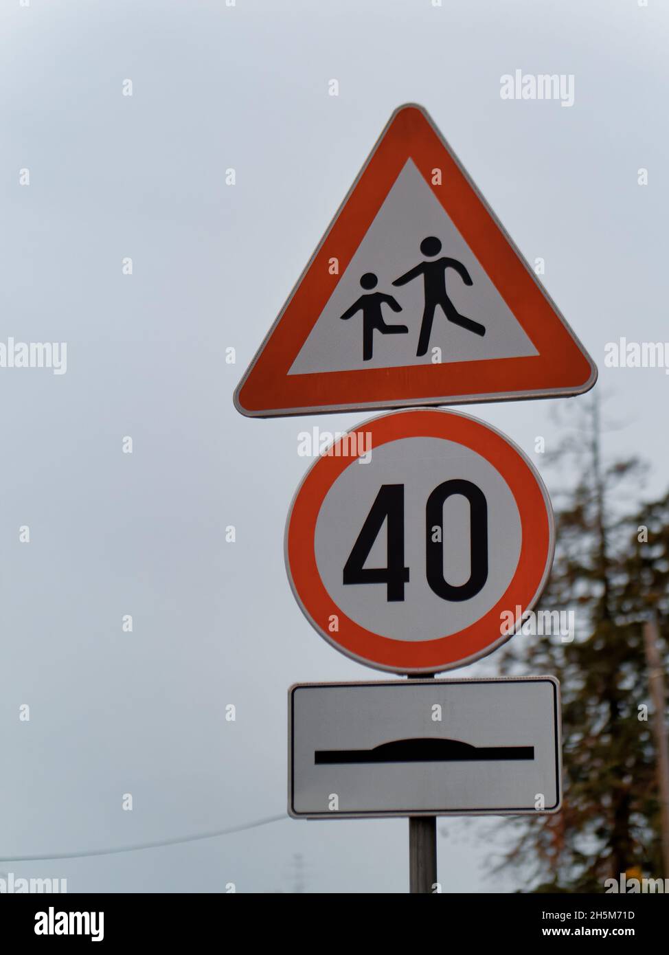 Warning pedestrian crossing sign, round speed limit 40 sign, andhump ...