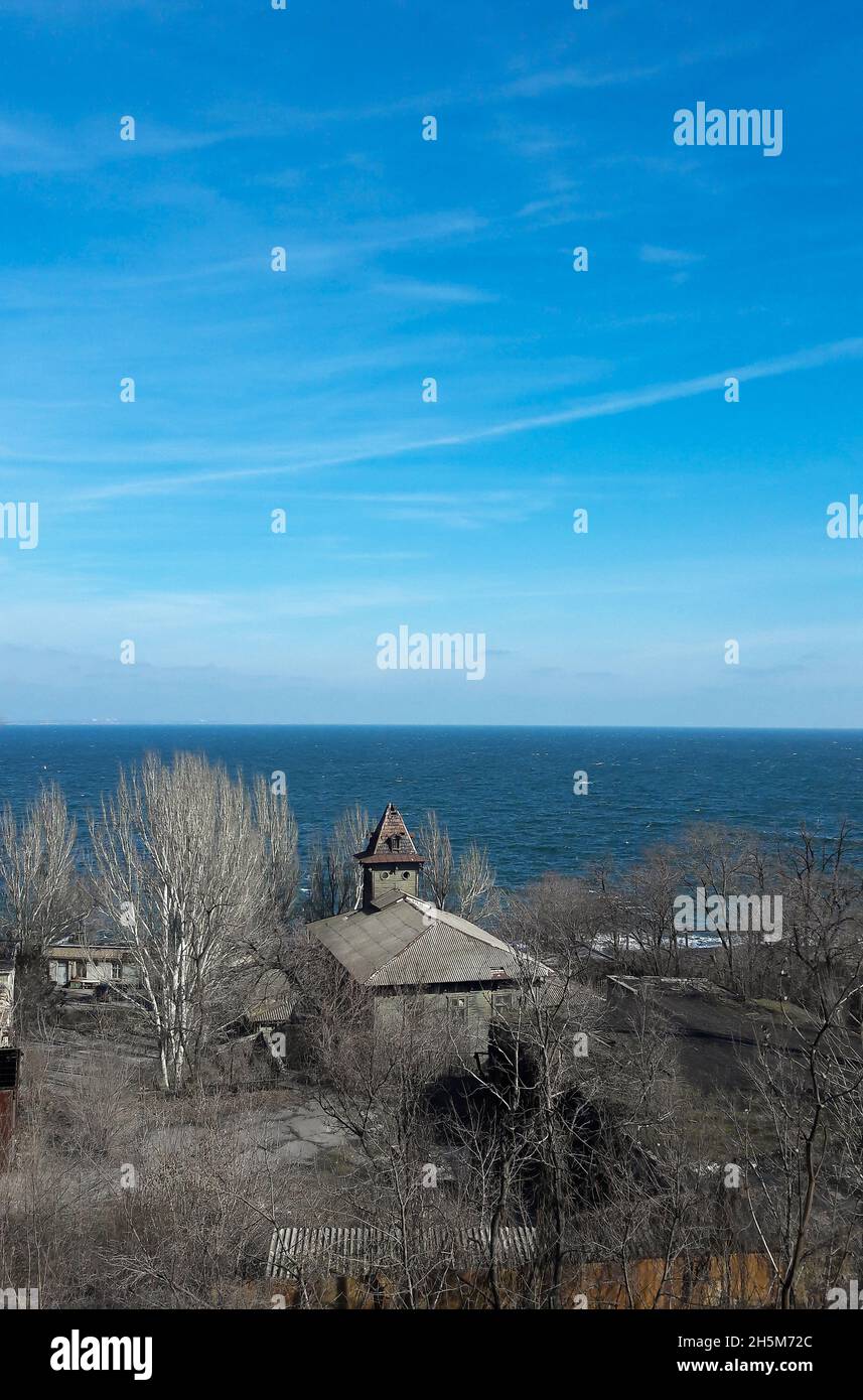 On the shore of the cold sea, there is an old wooden house with ...