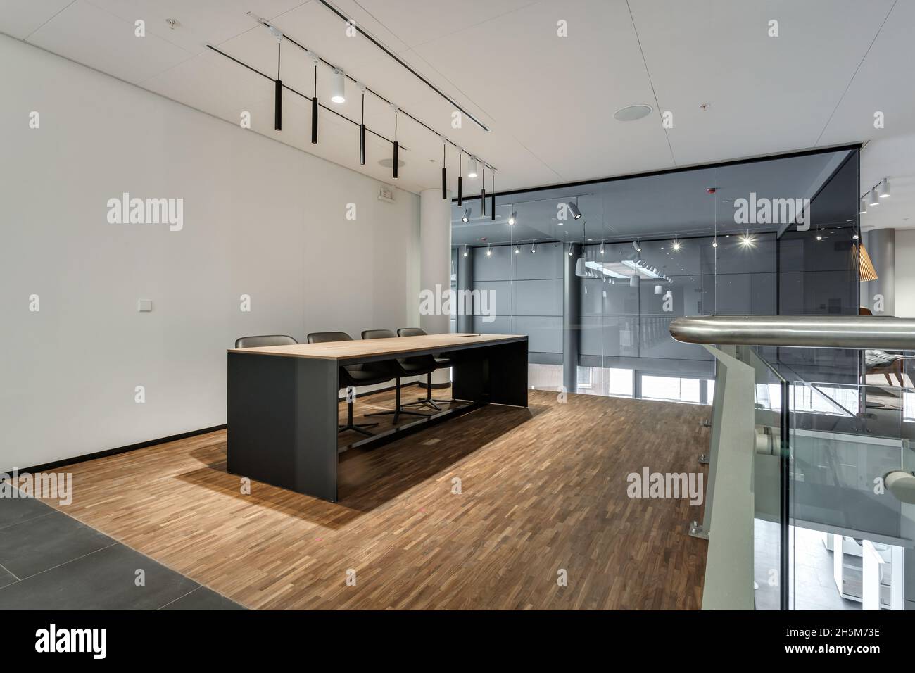 meeting table in modern office room with glass walls and thin long led ...