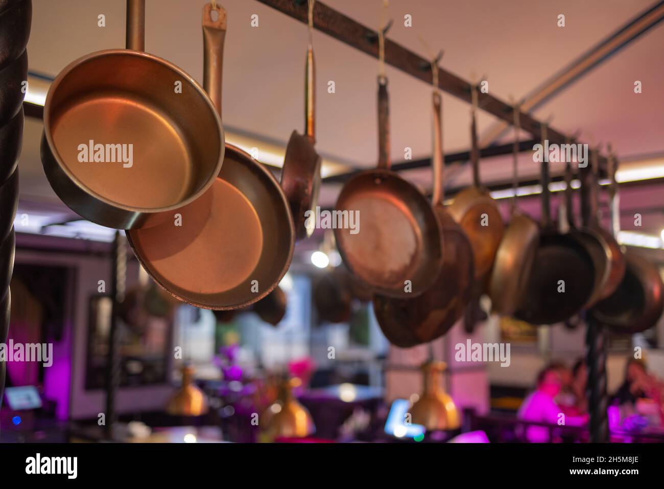 saucepans hanging from a rack in the kitchen Stock Photo - Alamy