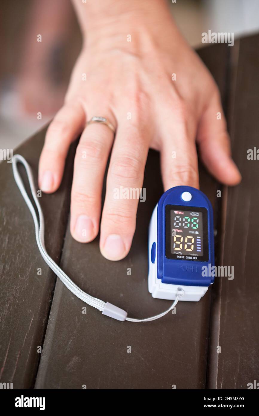 Female using oximeter for monitoring peripheral oxygen saturation ...