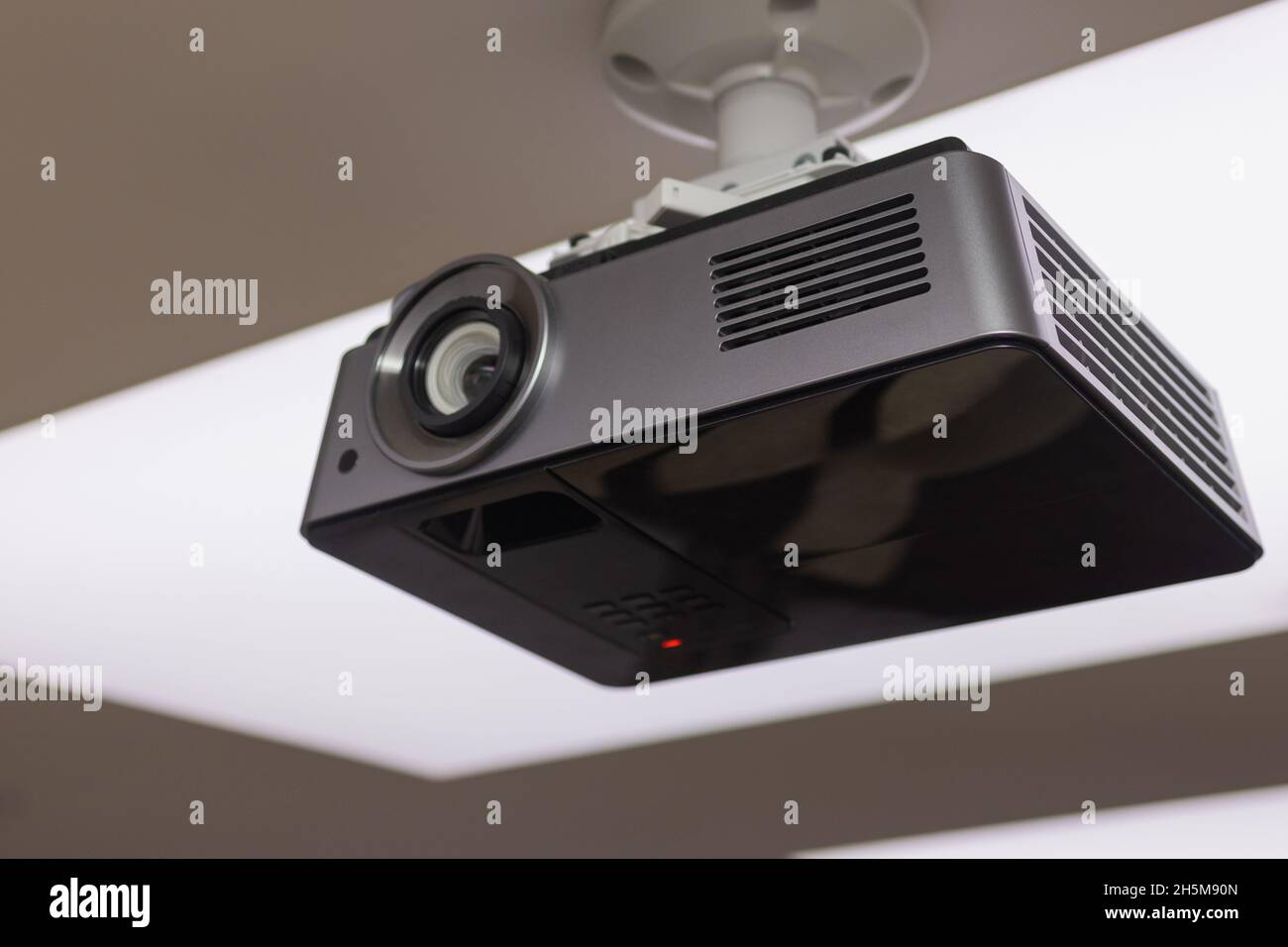 A black overhead projector on ceiling in a conference room modern ...
