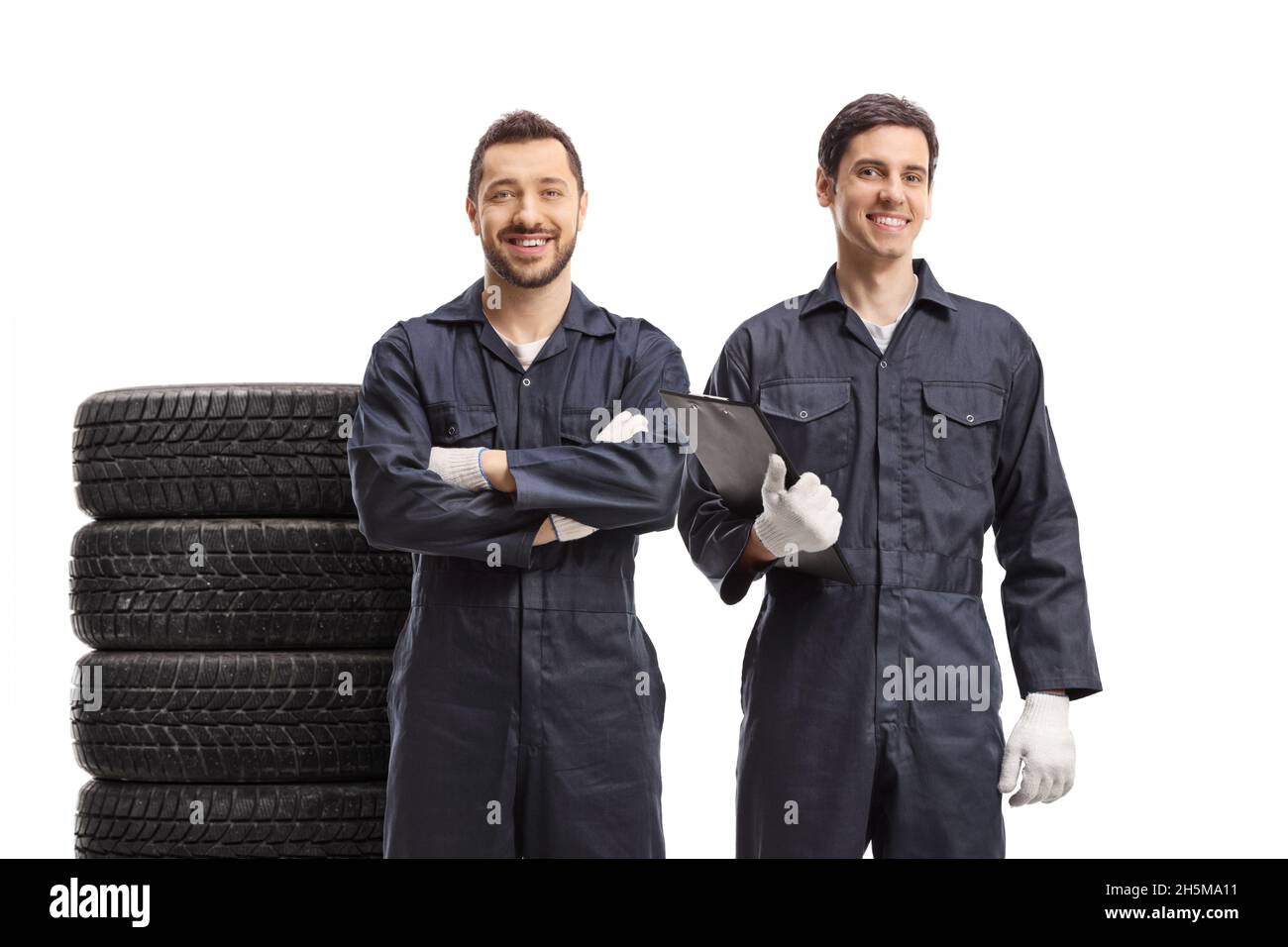 Two auto mechanic workers in uniforms with car tires isolated on white ...
