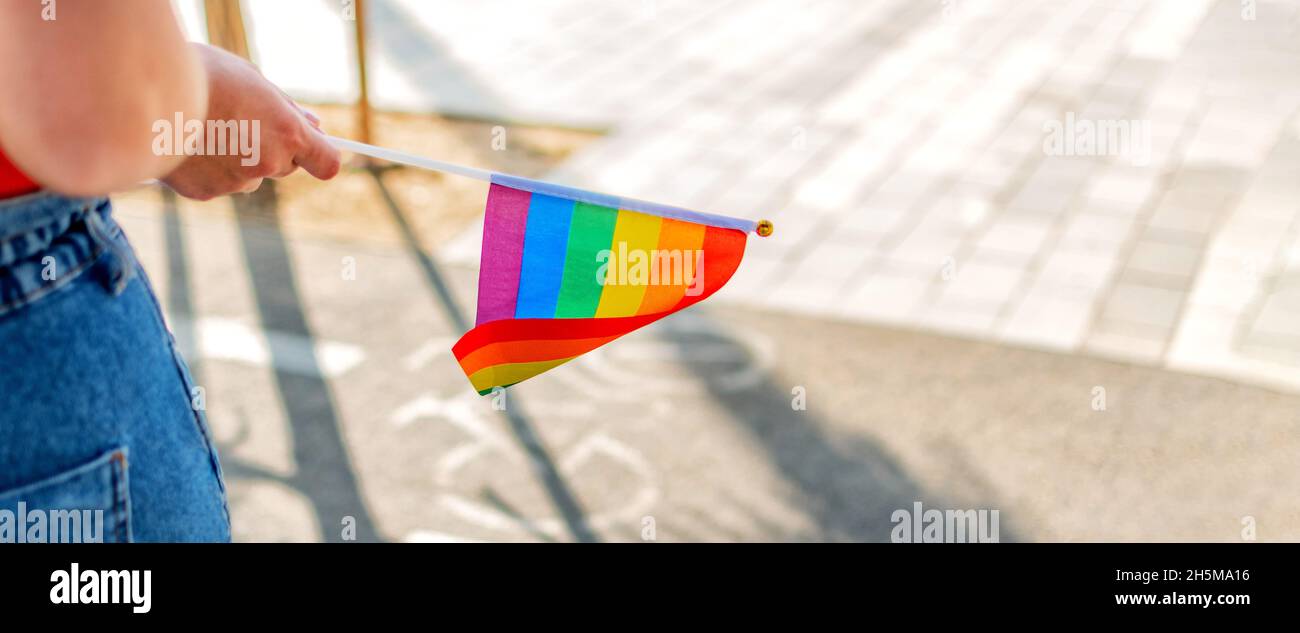 Person's hand holding the Rainbow Pride Flag Stock Photo - Alamy