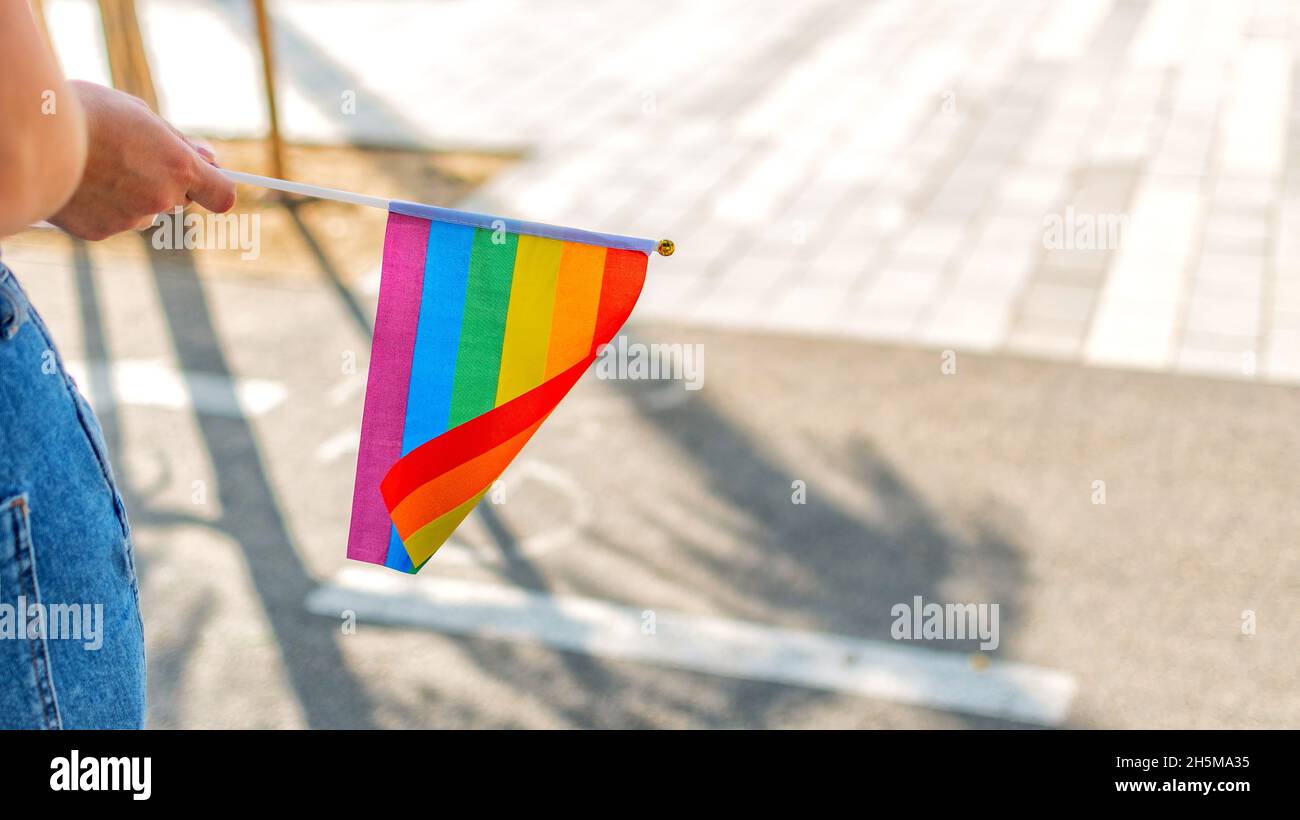Person's hand holding the Rainbow Pride Flag Stock Photo - Alamy