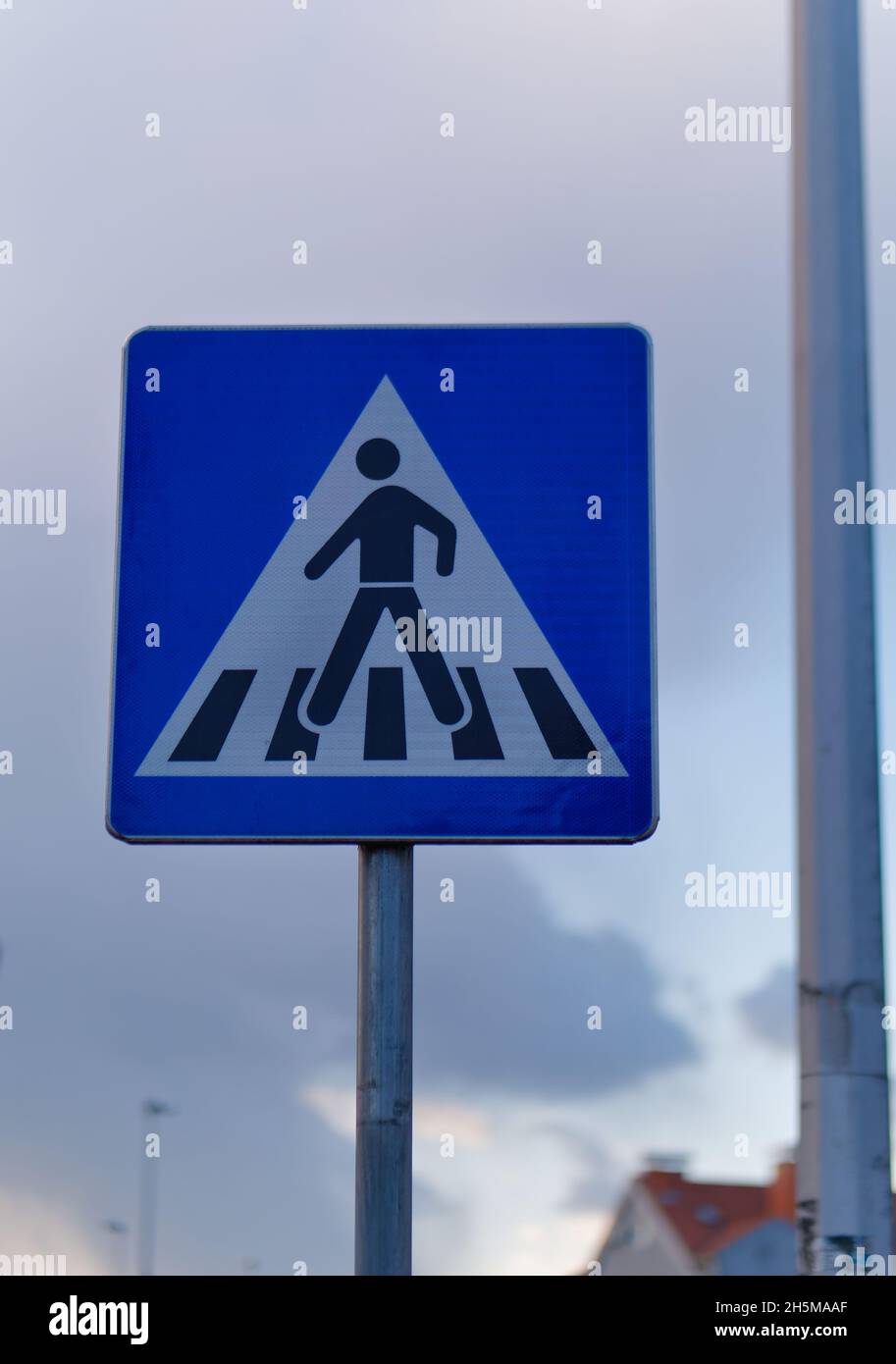 Vertical shot of a square pedestrian crossing sign attached on a pole ...