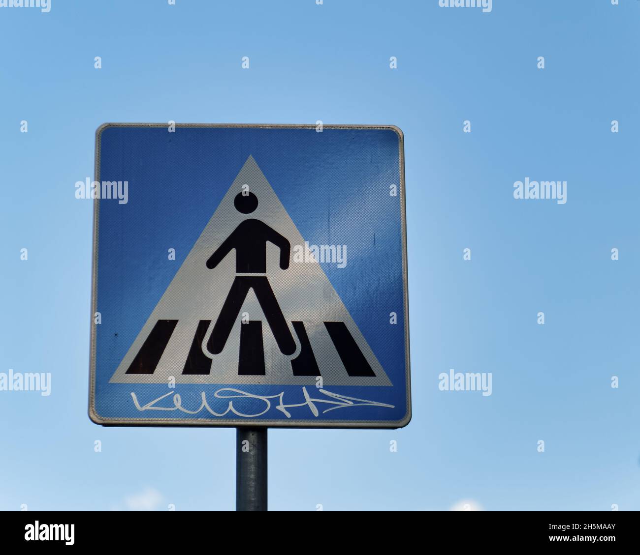 Close-up shot of a square pedestrian crossing sign attached on a pole ...