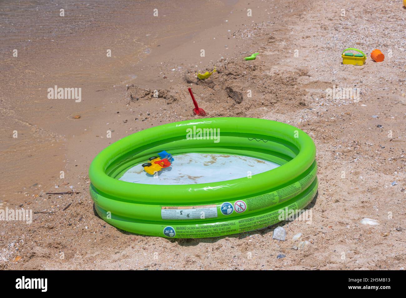 Close up view of empty inflatable pool and toys for sand on beach ...