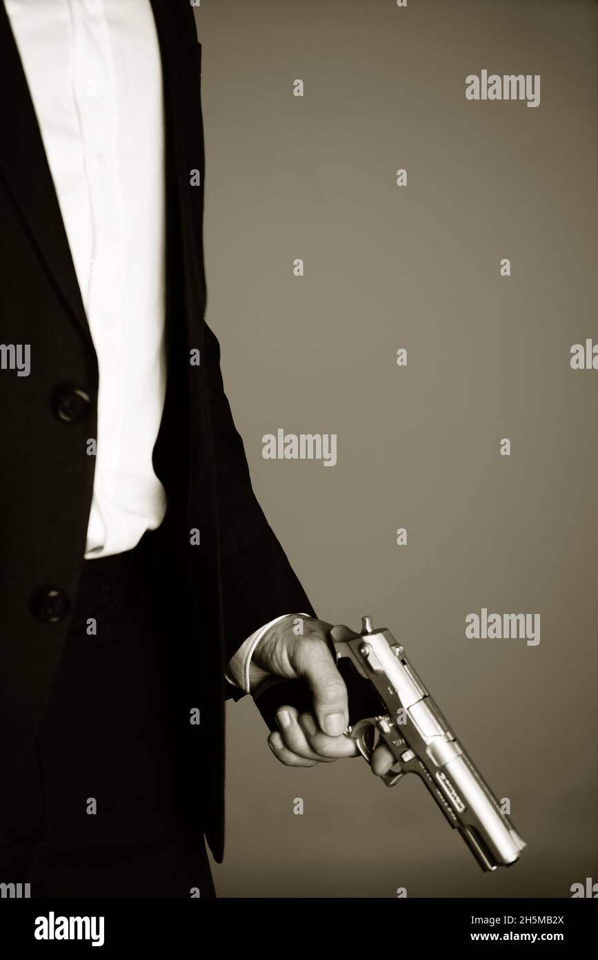 Retro secret agent with pistol revolver gun in hand in vintage crime ...