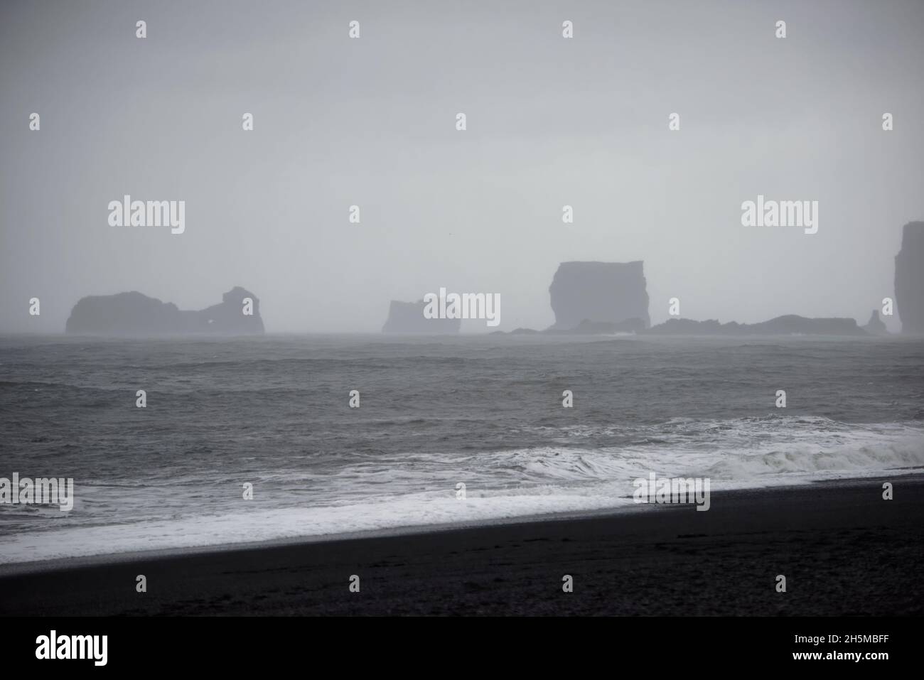 The Reynisdrangar basalt sea stacks and the Reynisfjara black sand ...