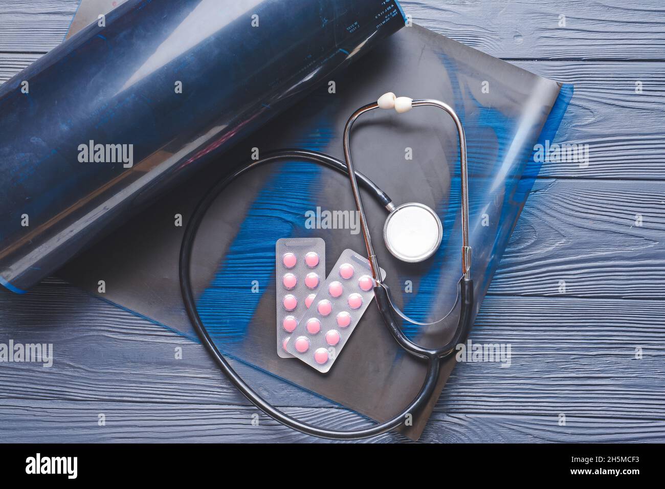 X-ray scan of lungs with stethoscope and pills on wooden background ...