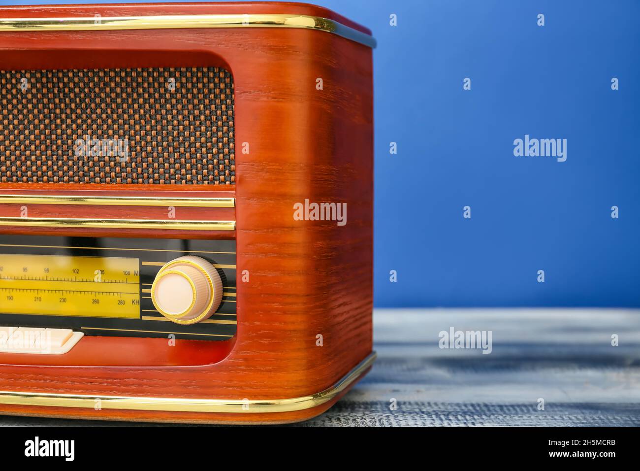 Retro radio receiver on table against color background Stock Photo - Alamy