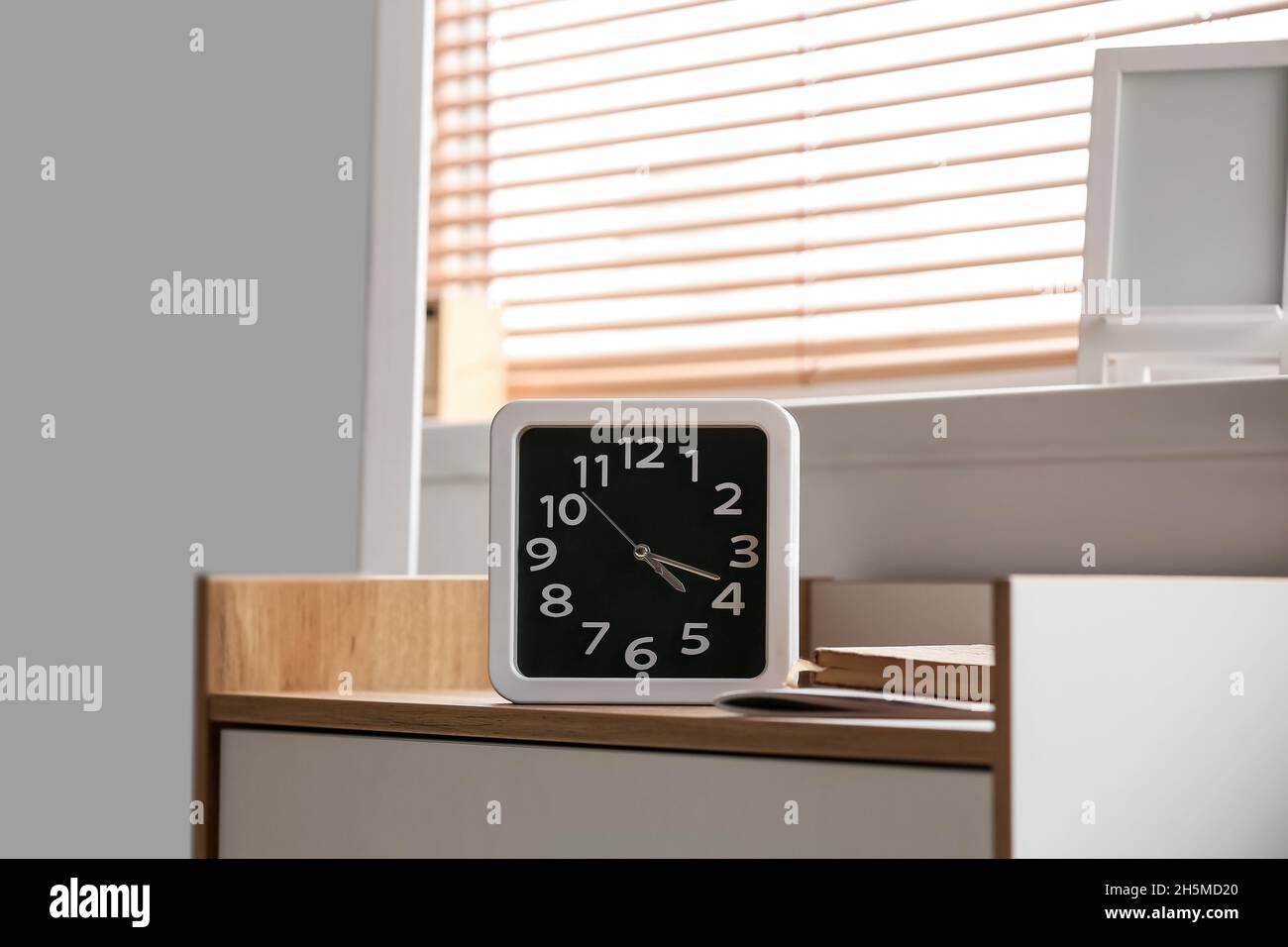 Clock on chest of drawers in room Stock Photo - Alamy