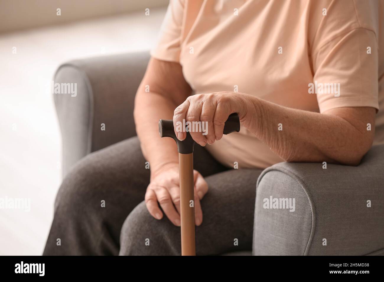 Elderly woman with walking stick at home Stock Photo - Alamy