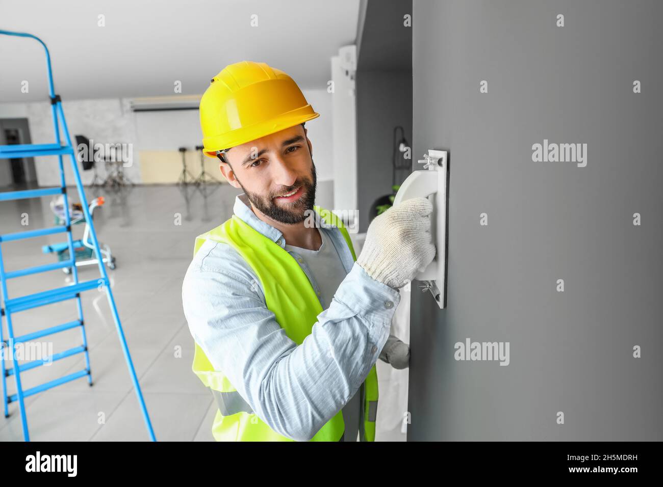Construction worker with burnishing trowel polishing wall in room Stock ...