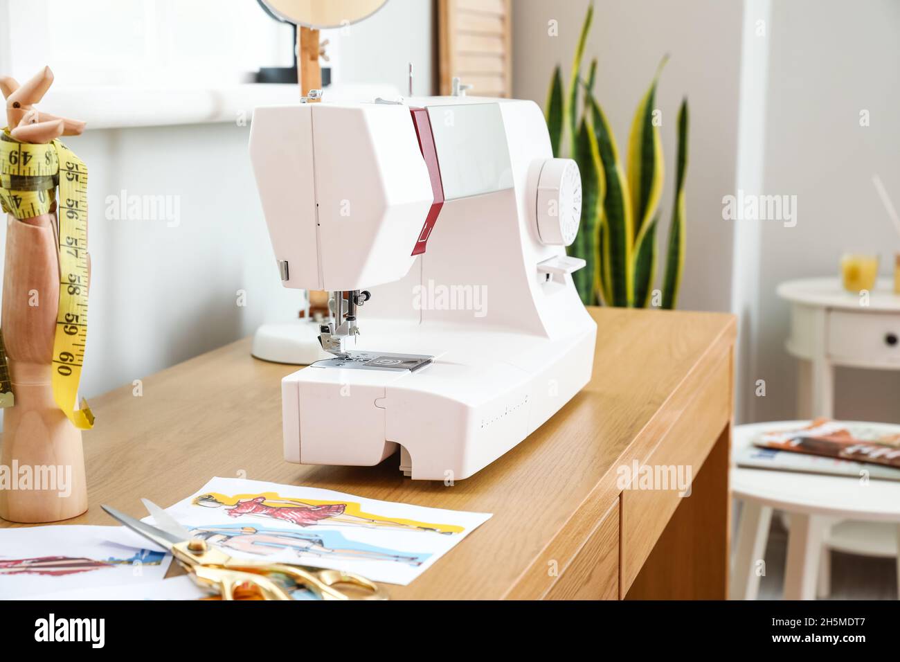 Modern sewing machine on wooden table in atelier Stock Photo - Alamy