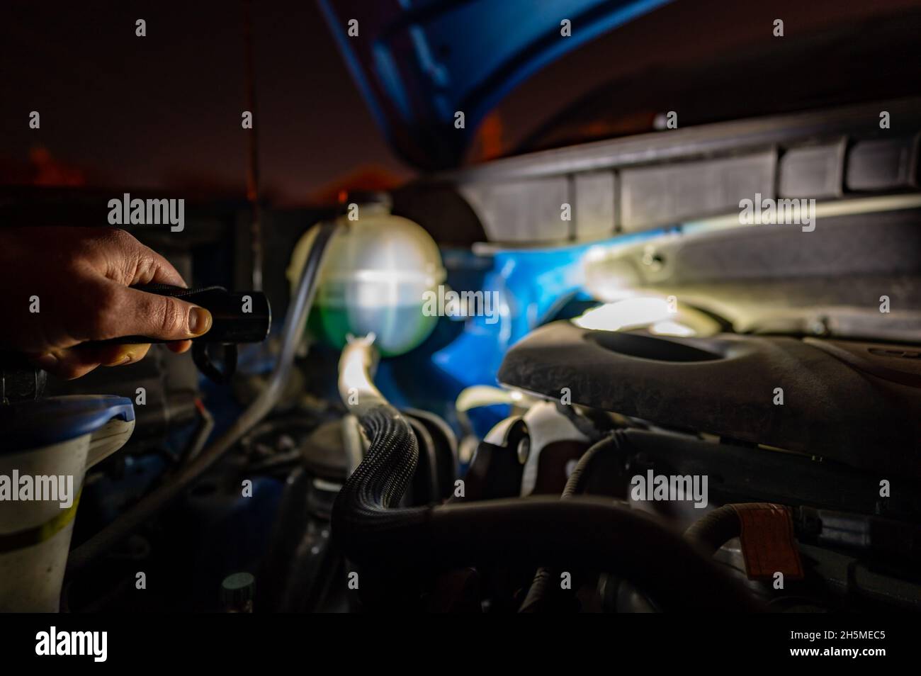 Shining a light into the open hood of vehicle to check the engine Stock ...