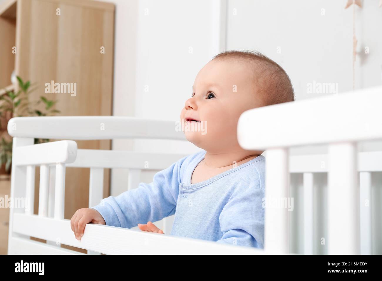 Cute little baby boy in crib Stock Photo - Alamy