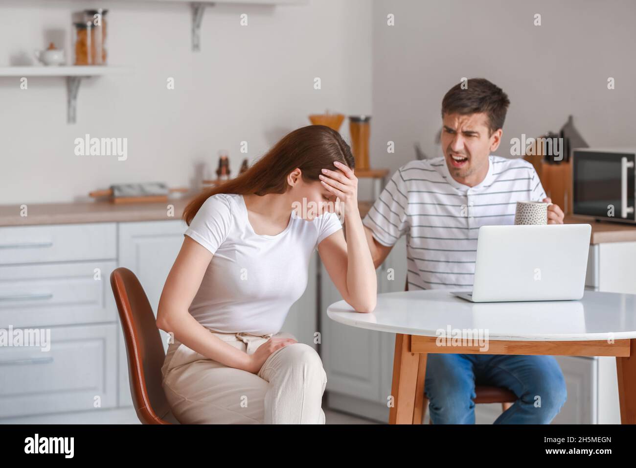 Young man shouting at his girlfriend in kitchen Stock Photo - Alamy