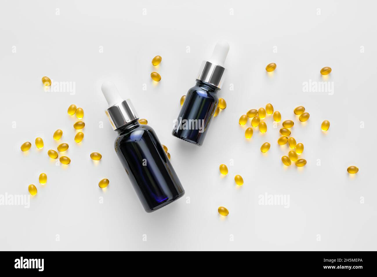 Bottles of essential oil and capsules on white background Stock Photo ...