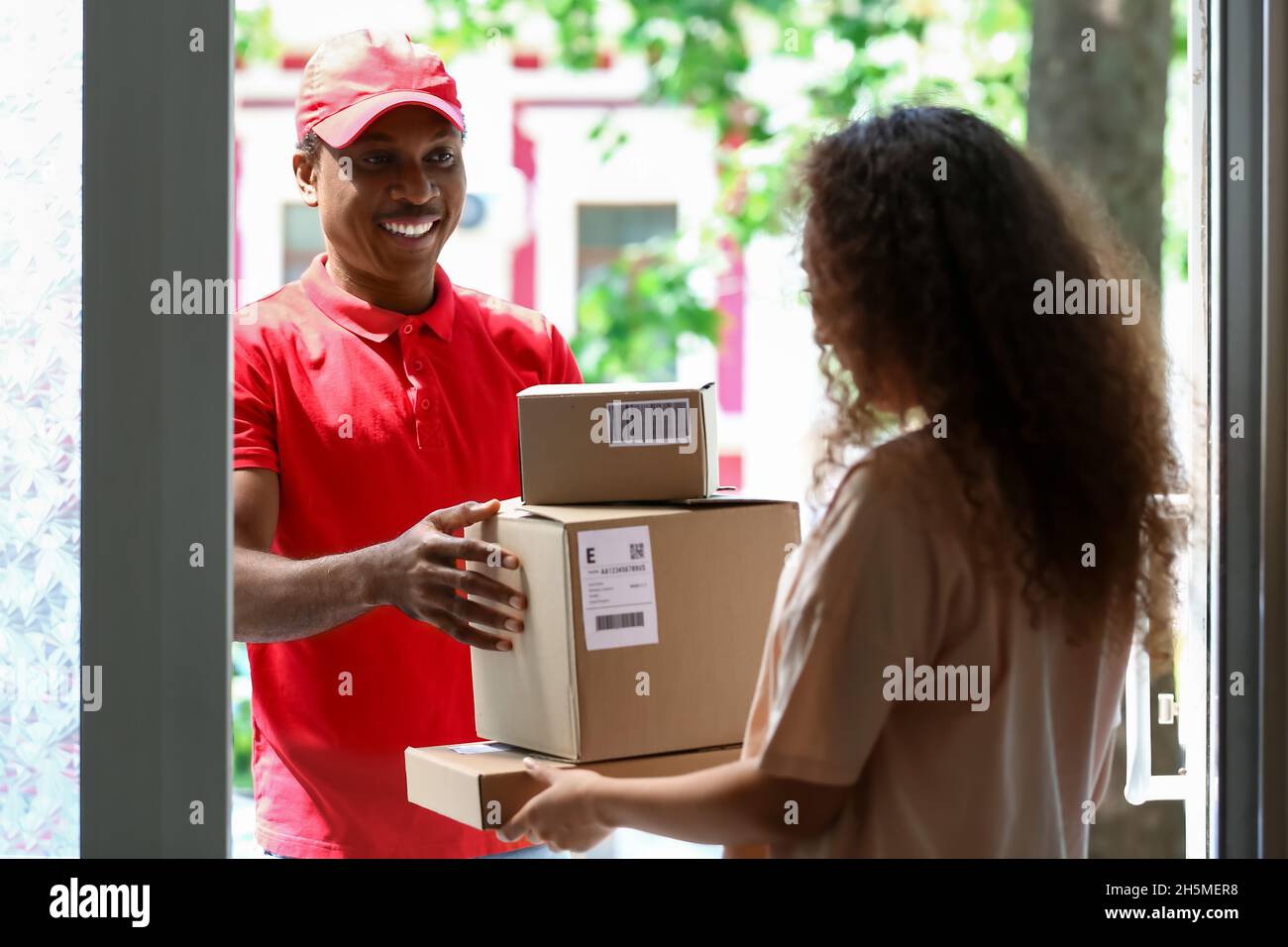 Customer receiving parcel from delivery man Stock Photo - Alamy