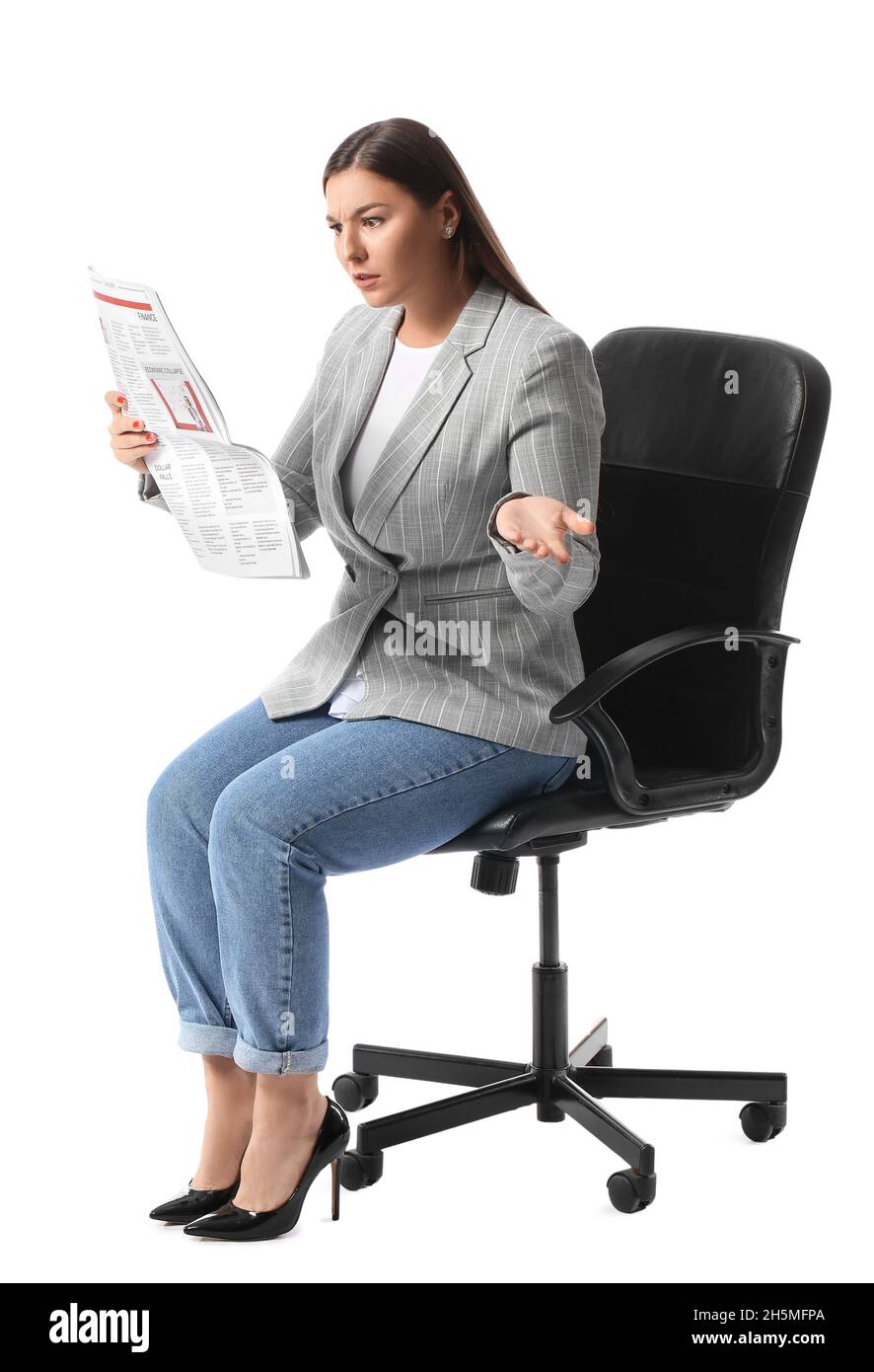 Confused businesswoman reading newspaper in chair on white background ...