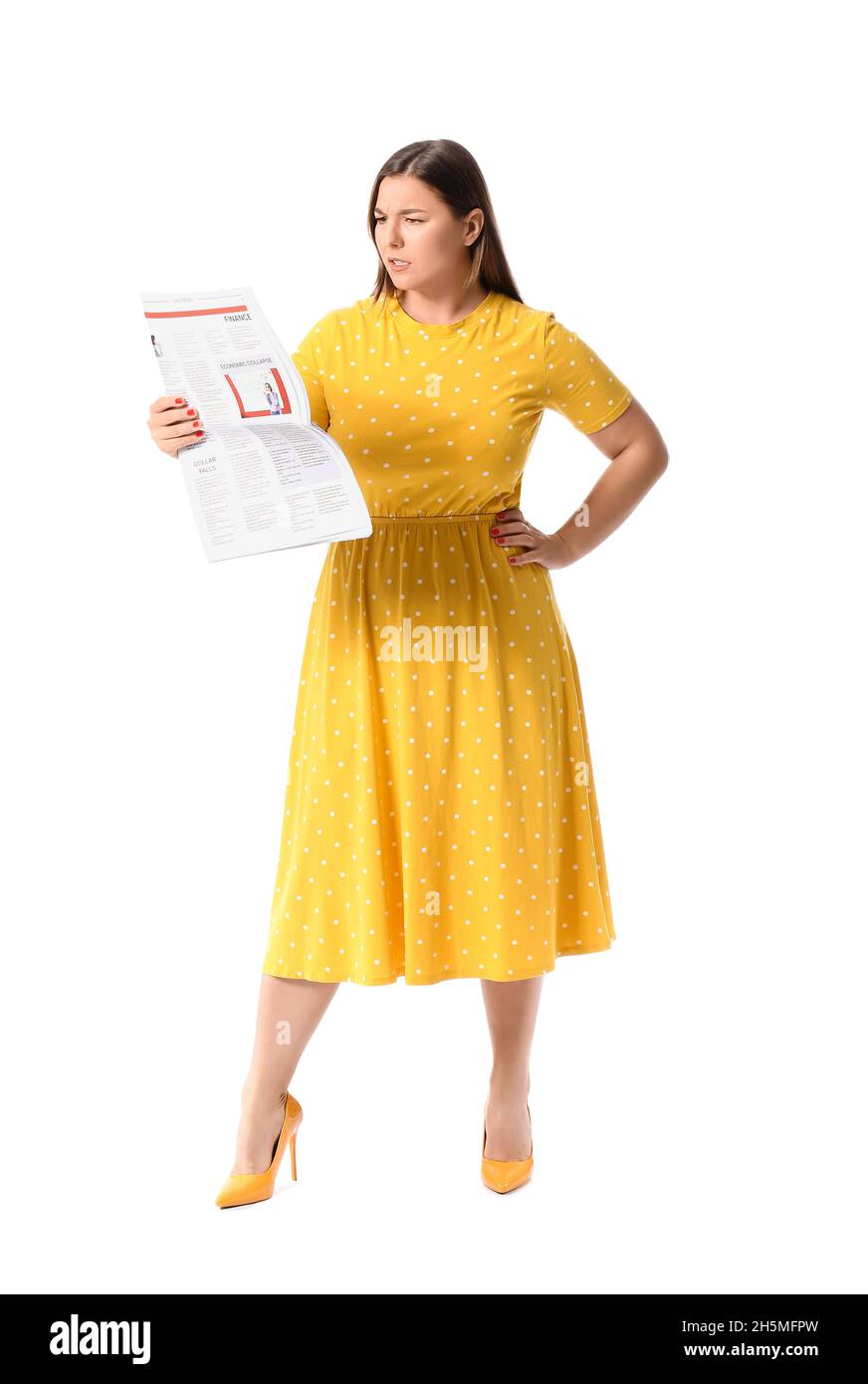 Upset young woman in yellow dress reading newspaper on white background ...