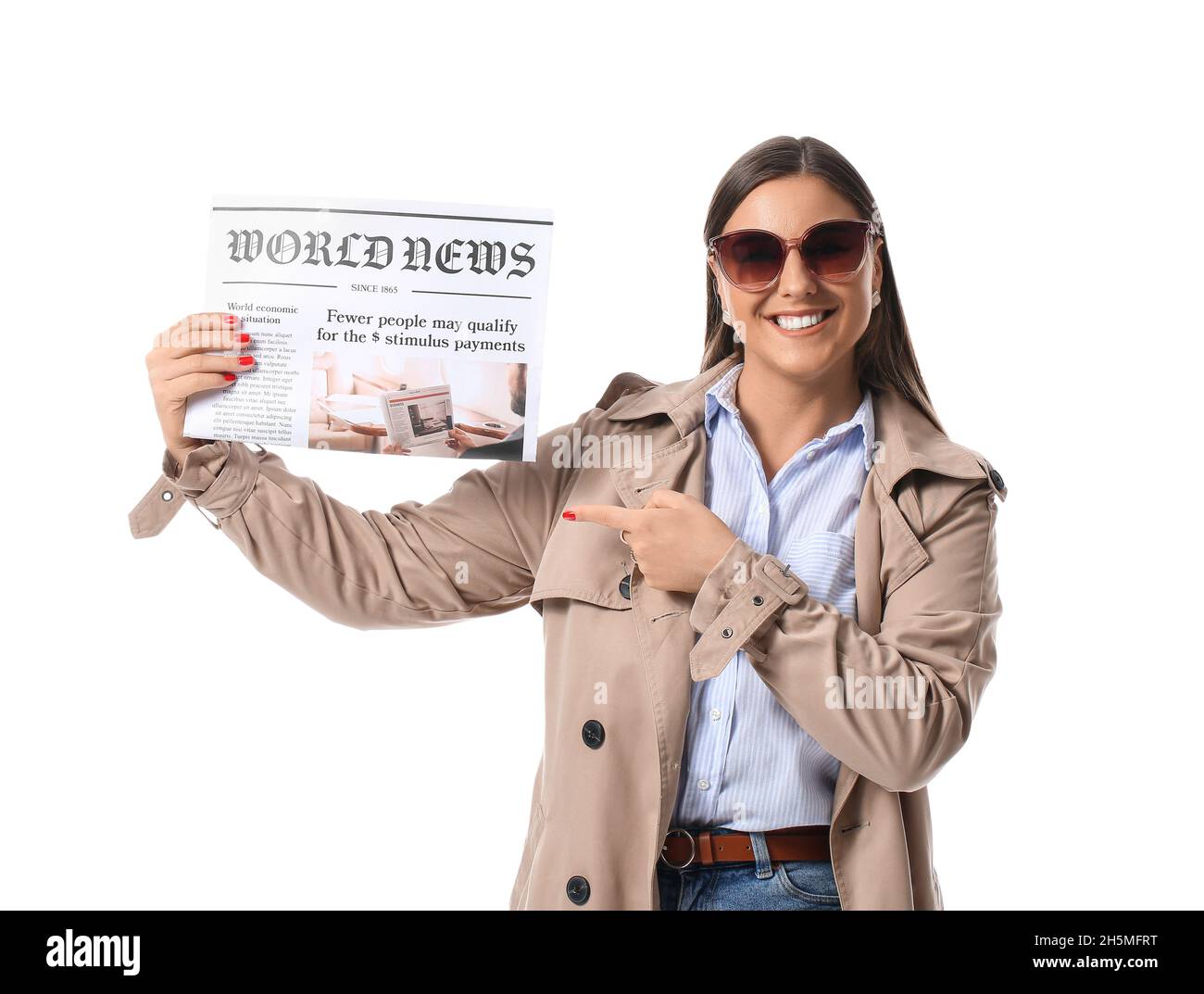 Young woman in sunglasses pointing at newspaper on white background ...