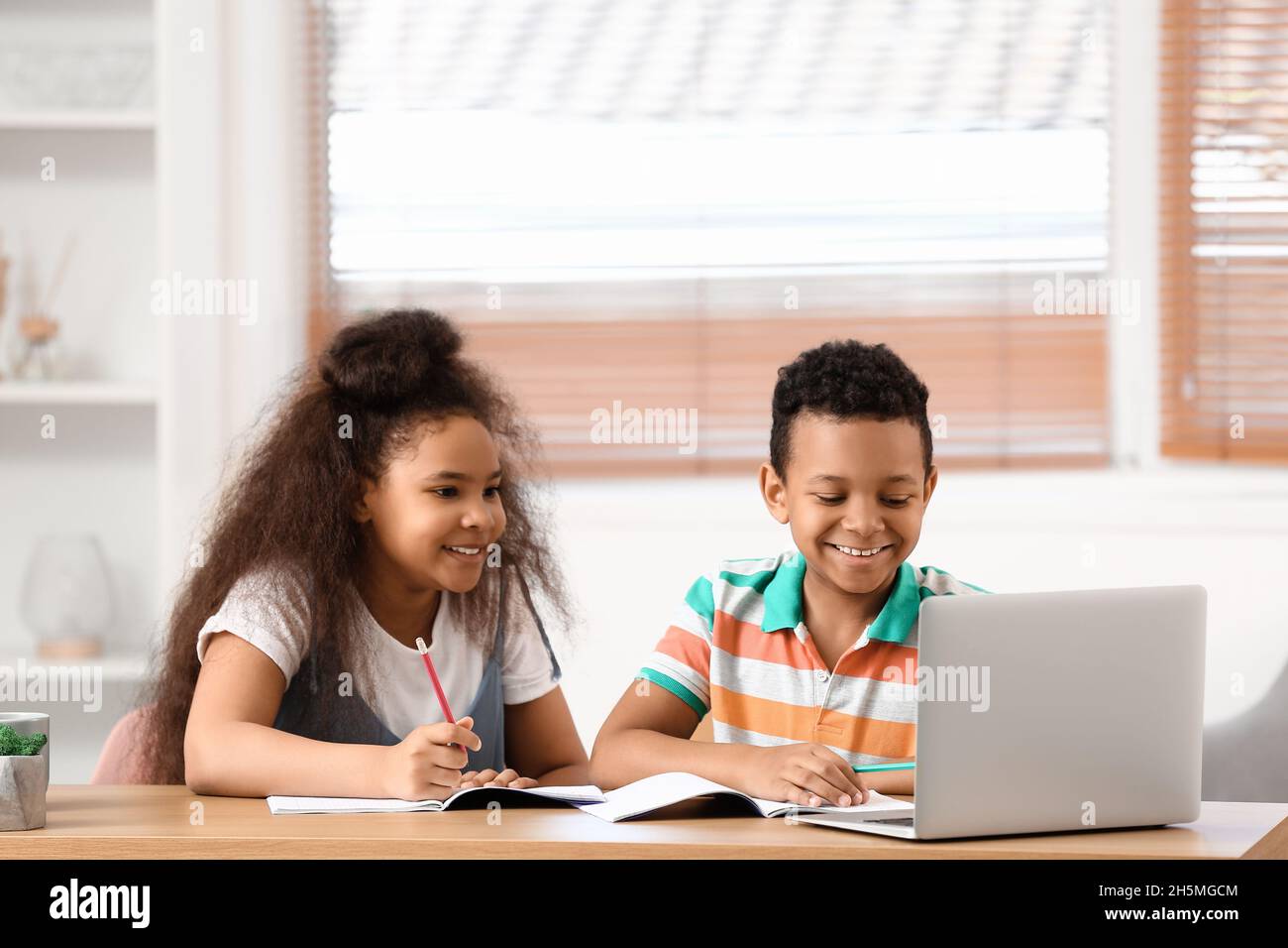 Little schoolchildren studying online at home Stock Photo - Alamy