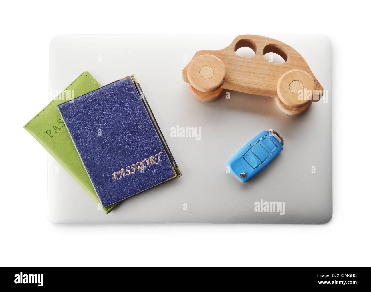 Laptop, toy automobile, passports and key fob on white background. Car ...
