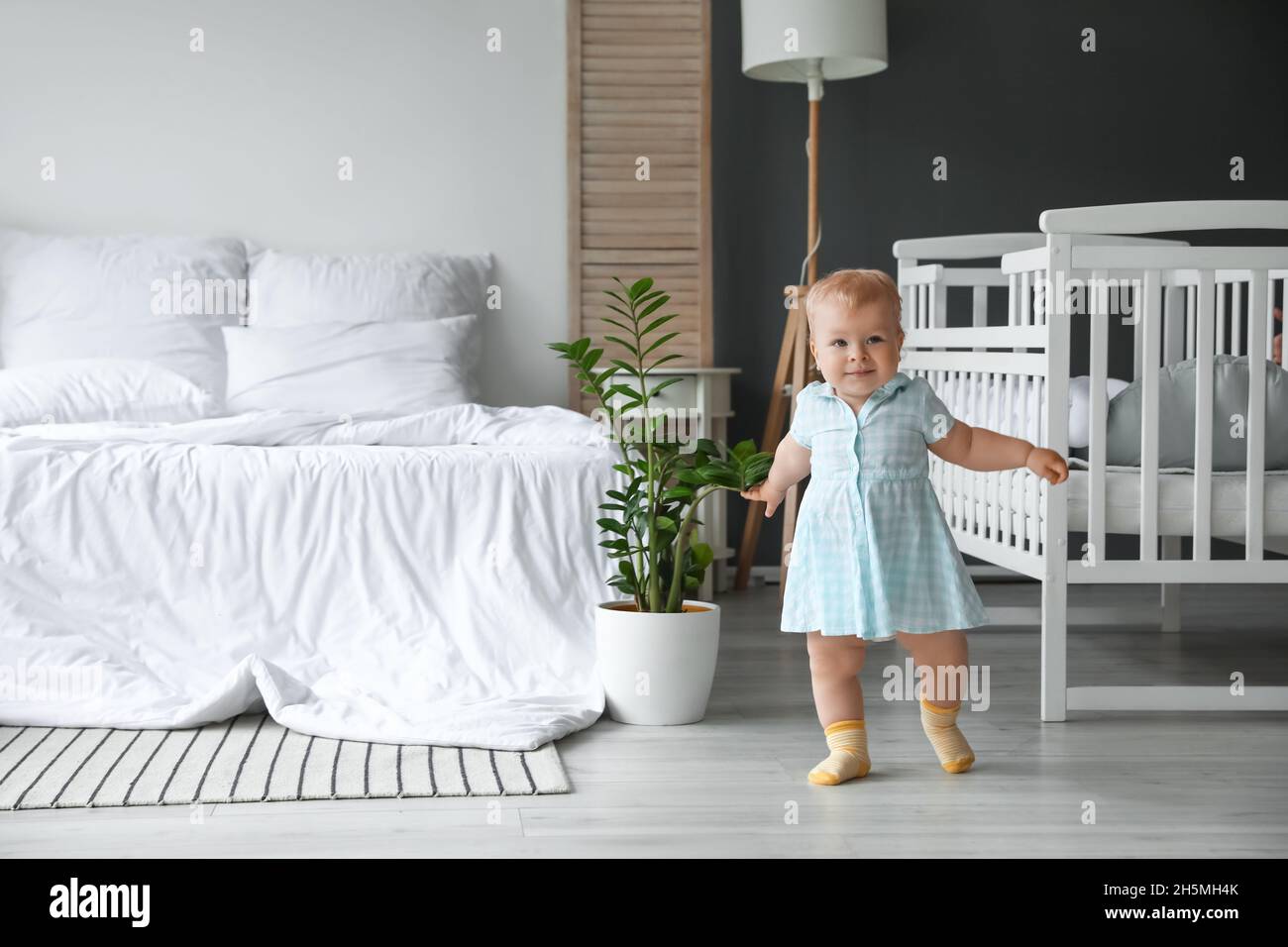 Cute baby girl learning to walk in bedroom Stock Photo - Alamy