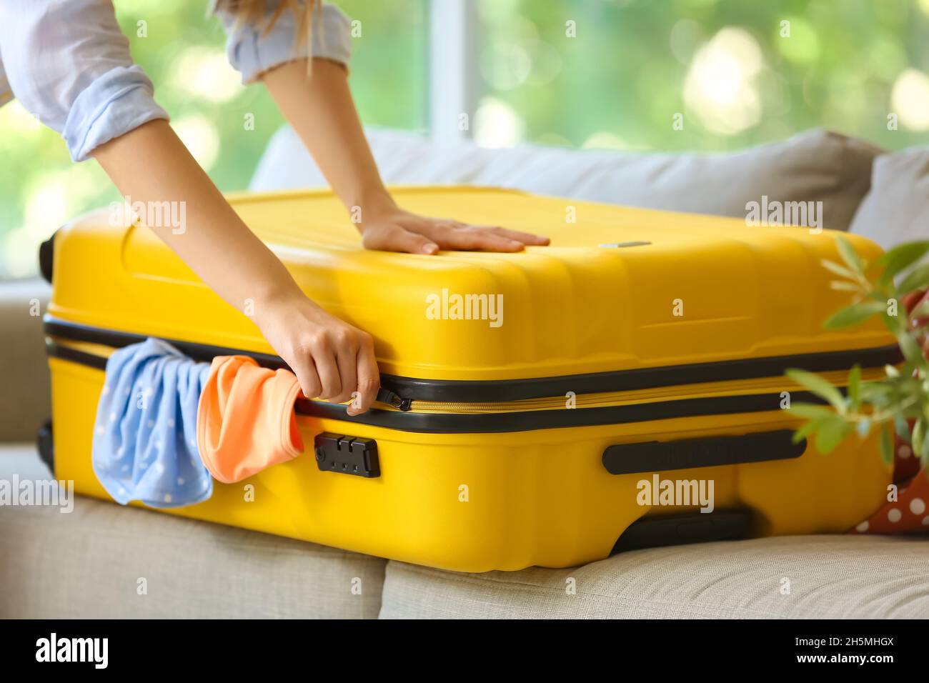 Female tourist trying to close suitcase with a lot of things Stock ...