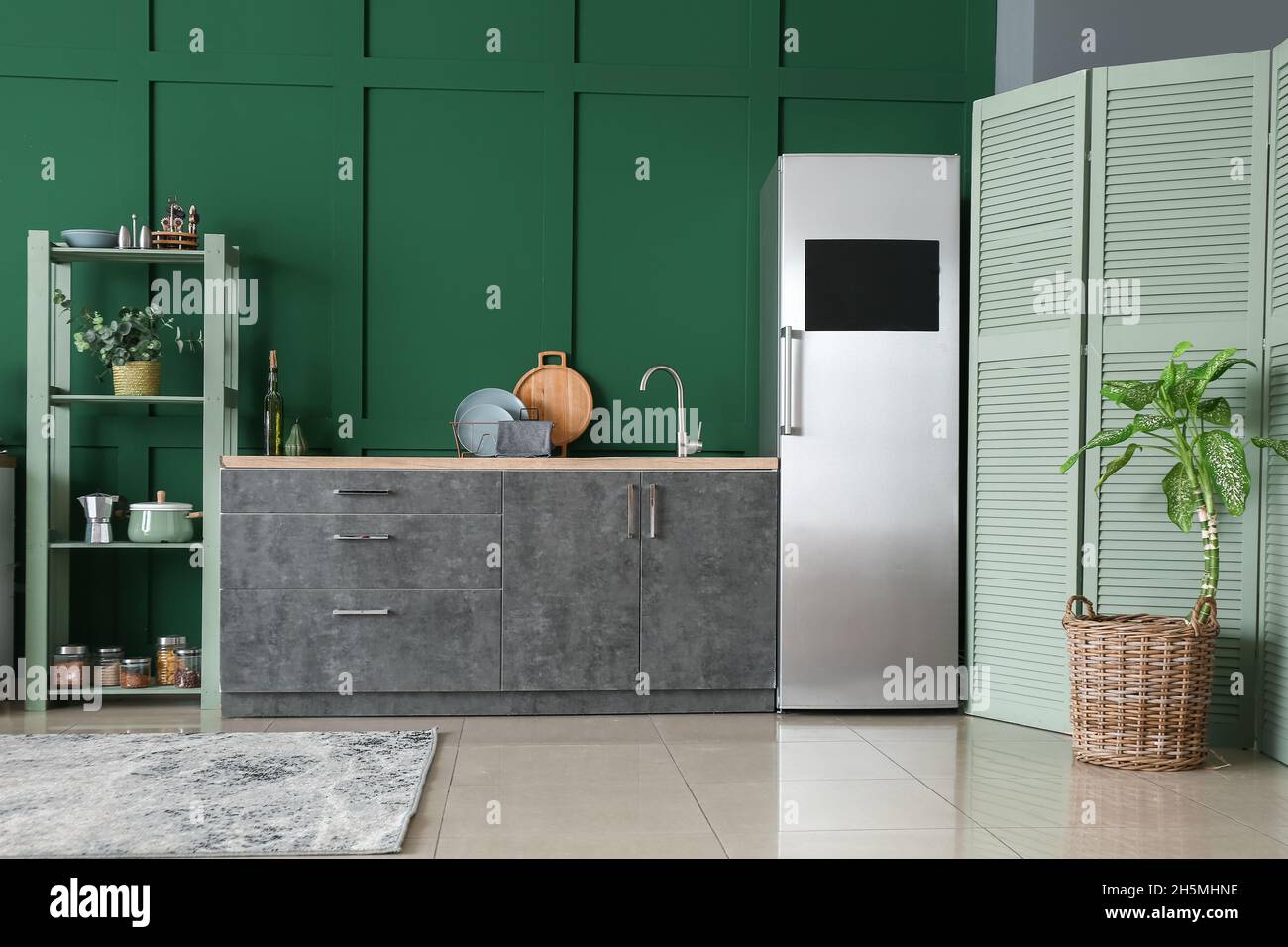 Interior of modern kitchen with fridge and green wall Stock Photo - Alamy
