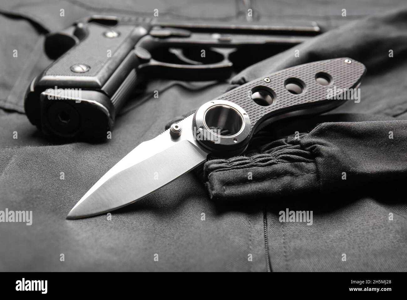 Folding pocket knife with pistol on black suit background Stock Photo ...