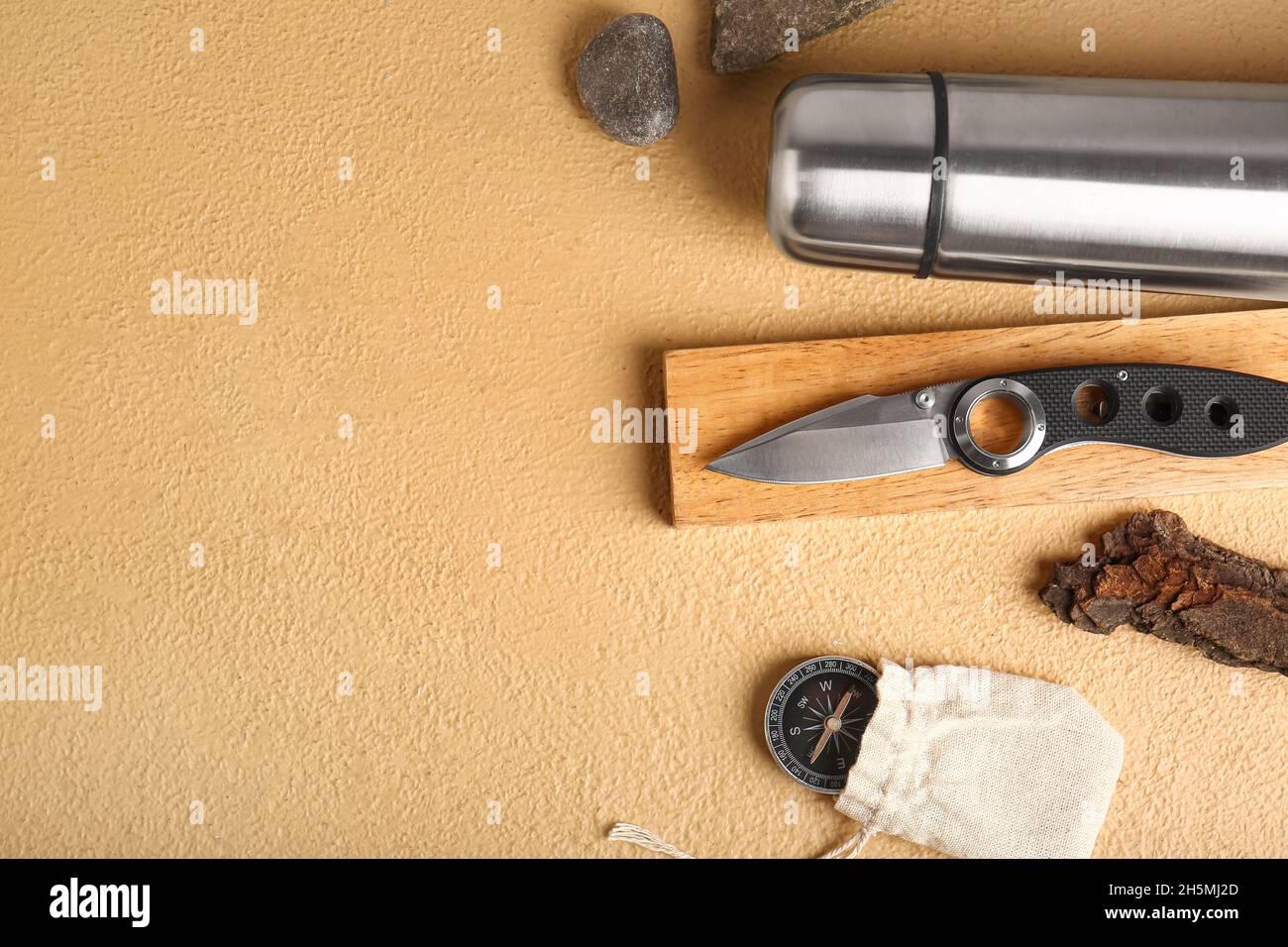 Folding pocket knife, thermos and compass on table Stock Photo - Alamy