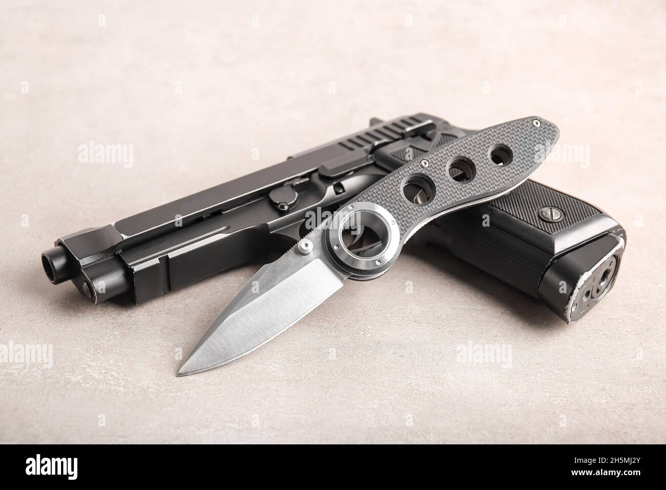 Folding pocket knife and gun on table Stock Photo - Alamy