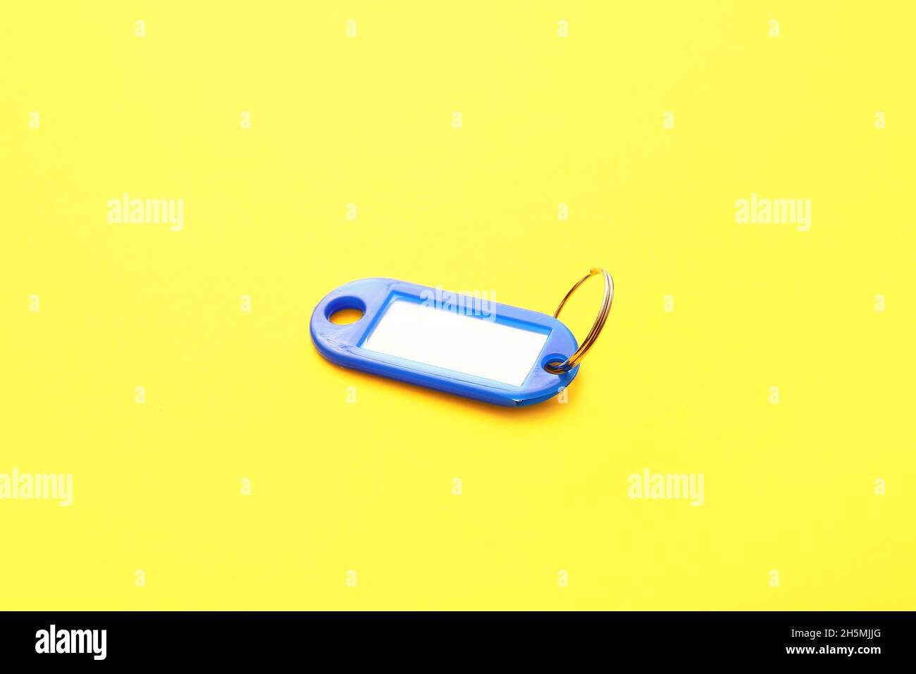 Plastic key tag on yellow background Stock Photo - Alamy