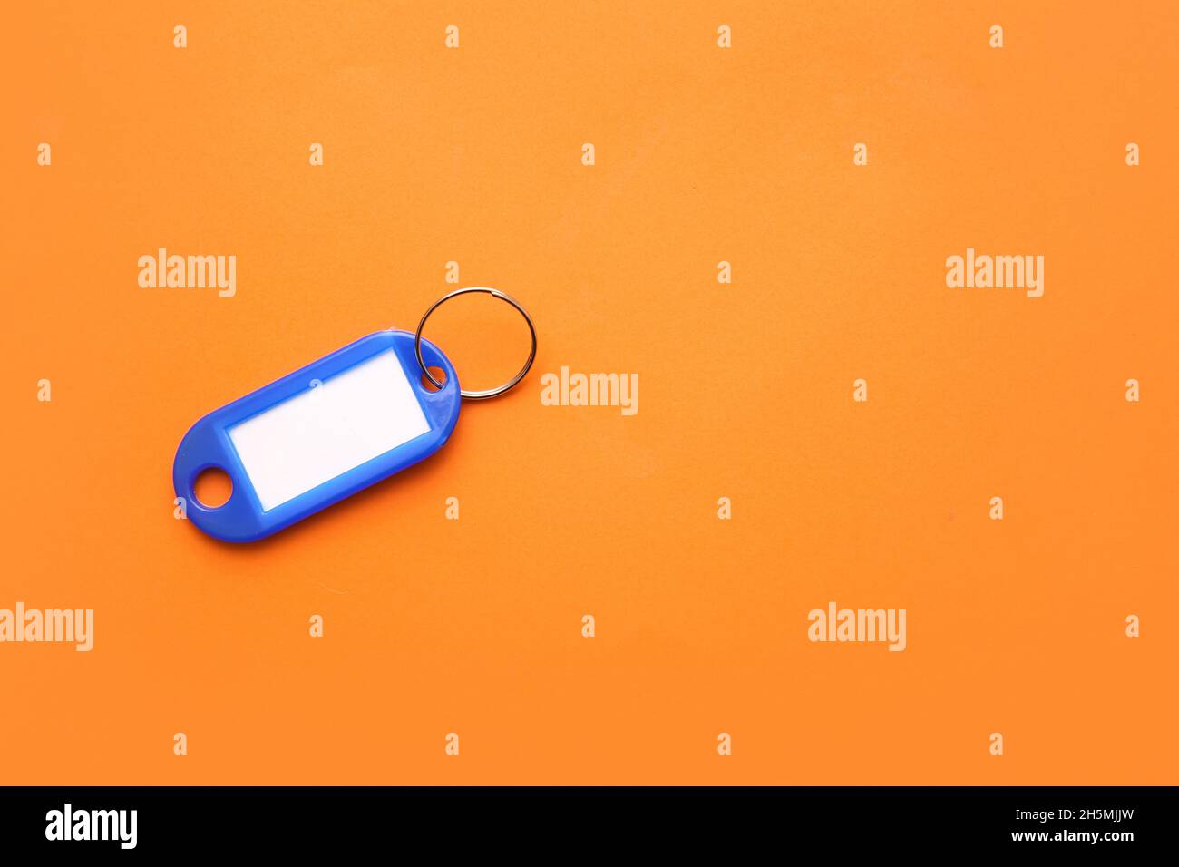Plastic key tag on orange background Stock Photo - Alamy