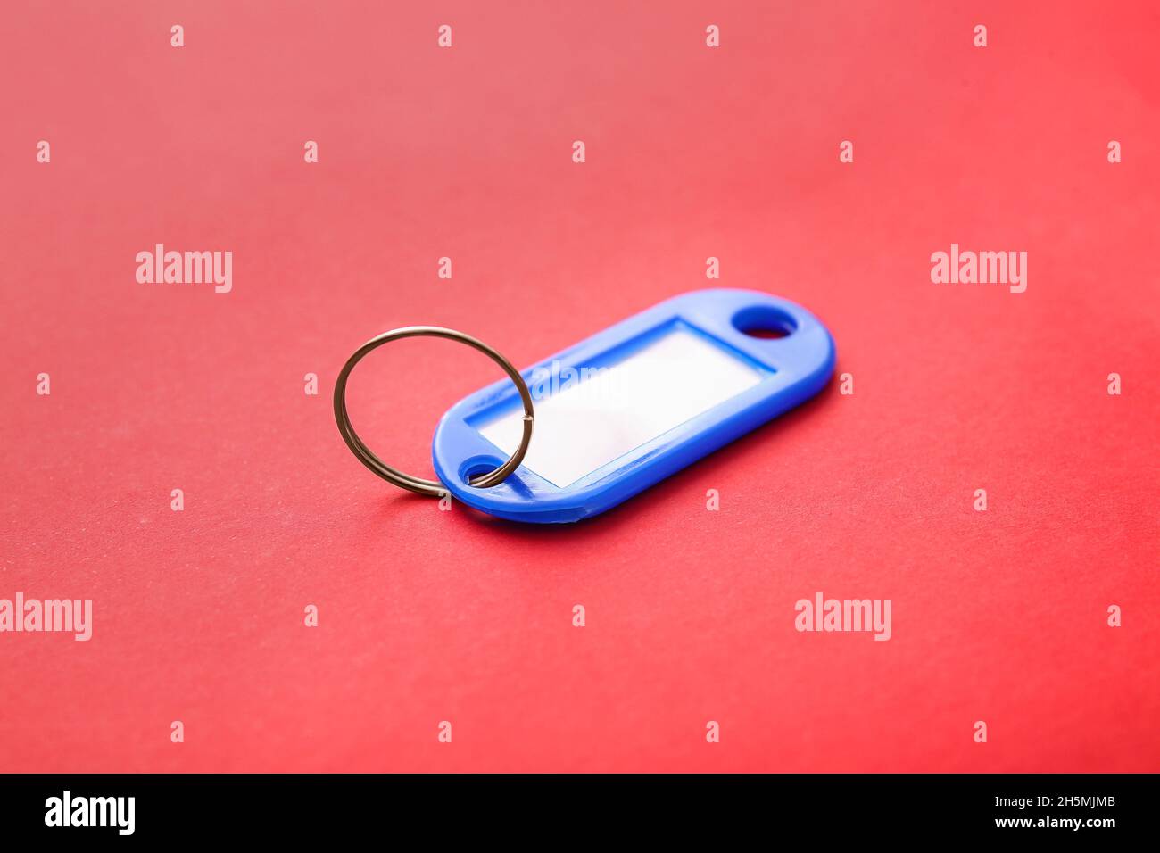Plastic key tag on red background Stock Photo - Alamy