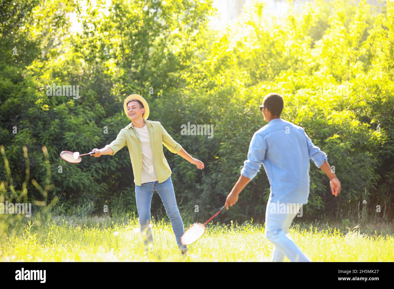 Young men playing badminton outdoors Stock Photo - Alamy