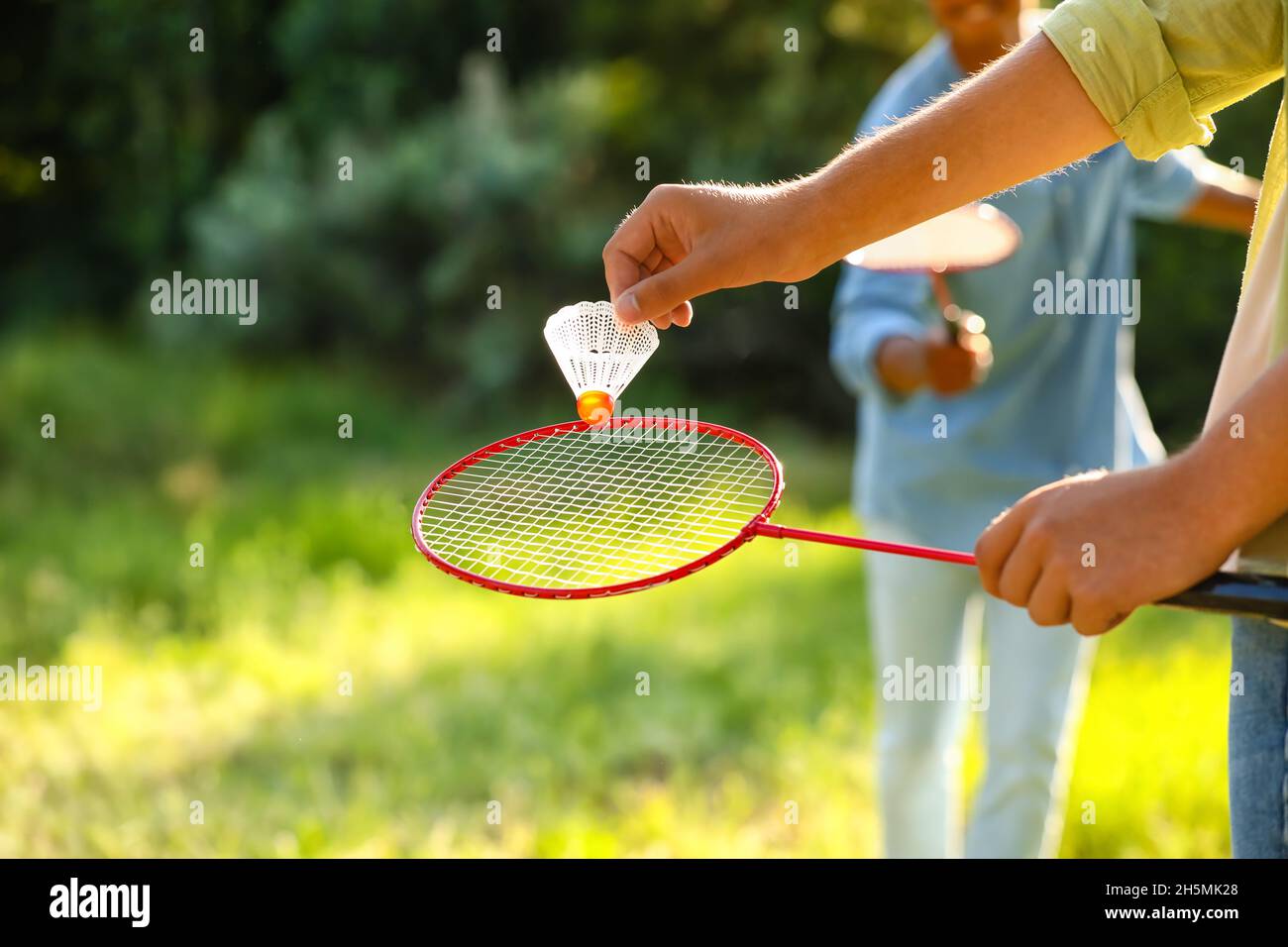 Young men playing badminton outdoors Stock Photo - Alamy
