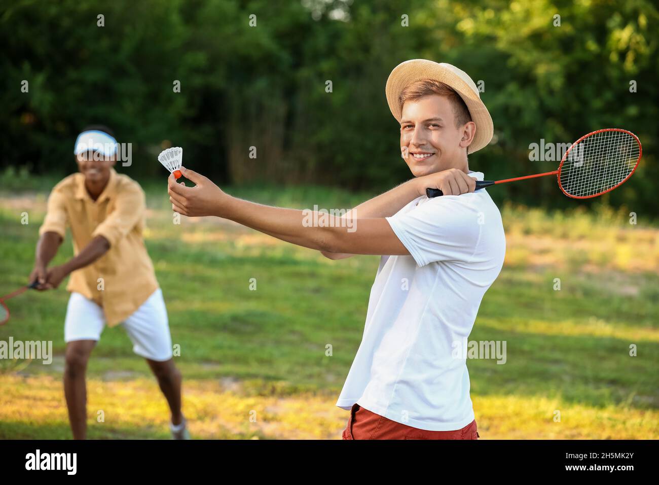 Young men playing badminton outdoors Stock Photo - Alamy