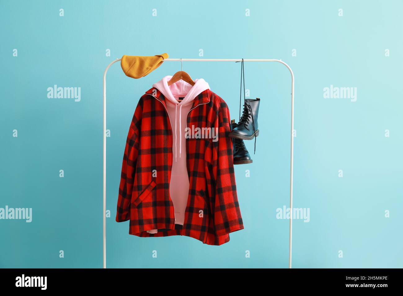 Rack with modern clothes and accessories on color background Stock ...