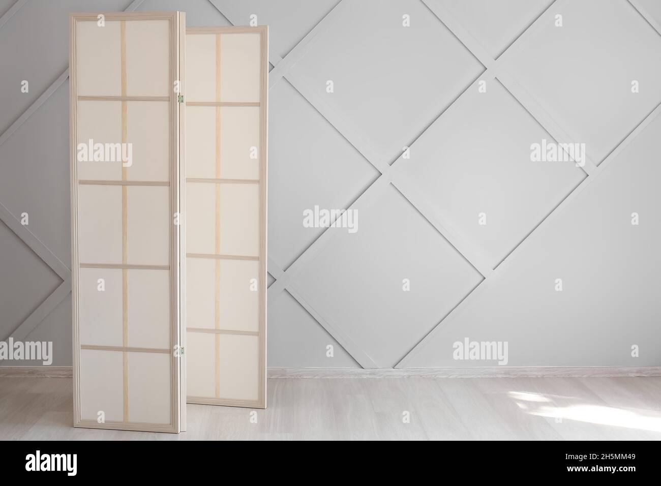 Stylish folding screen in room interior on wall background Stock Photo ...