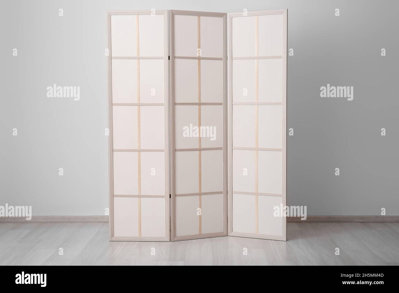 Stylish folding screen in room interior on wall background Stock Photo ...
