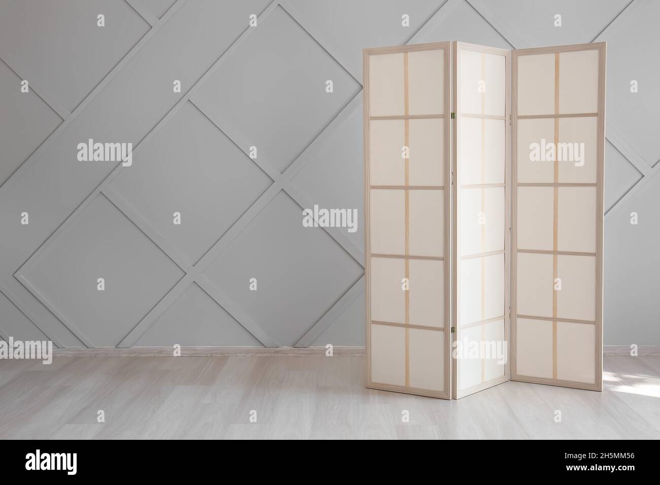 Stylish folding screen in room interior on wall background Stock Photo ...