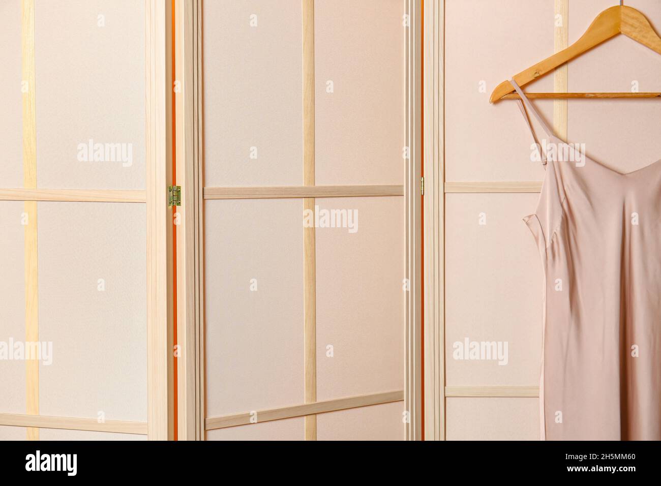 Folding screen with dress in room Stock Photo - Alamy