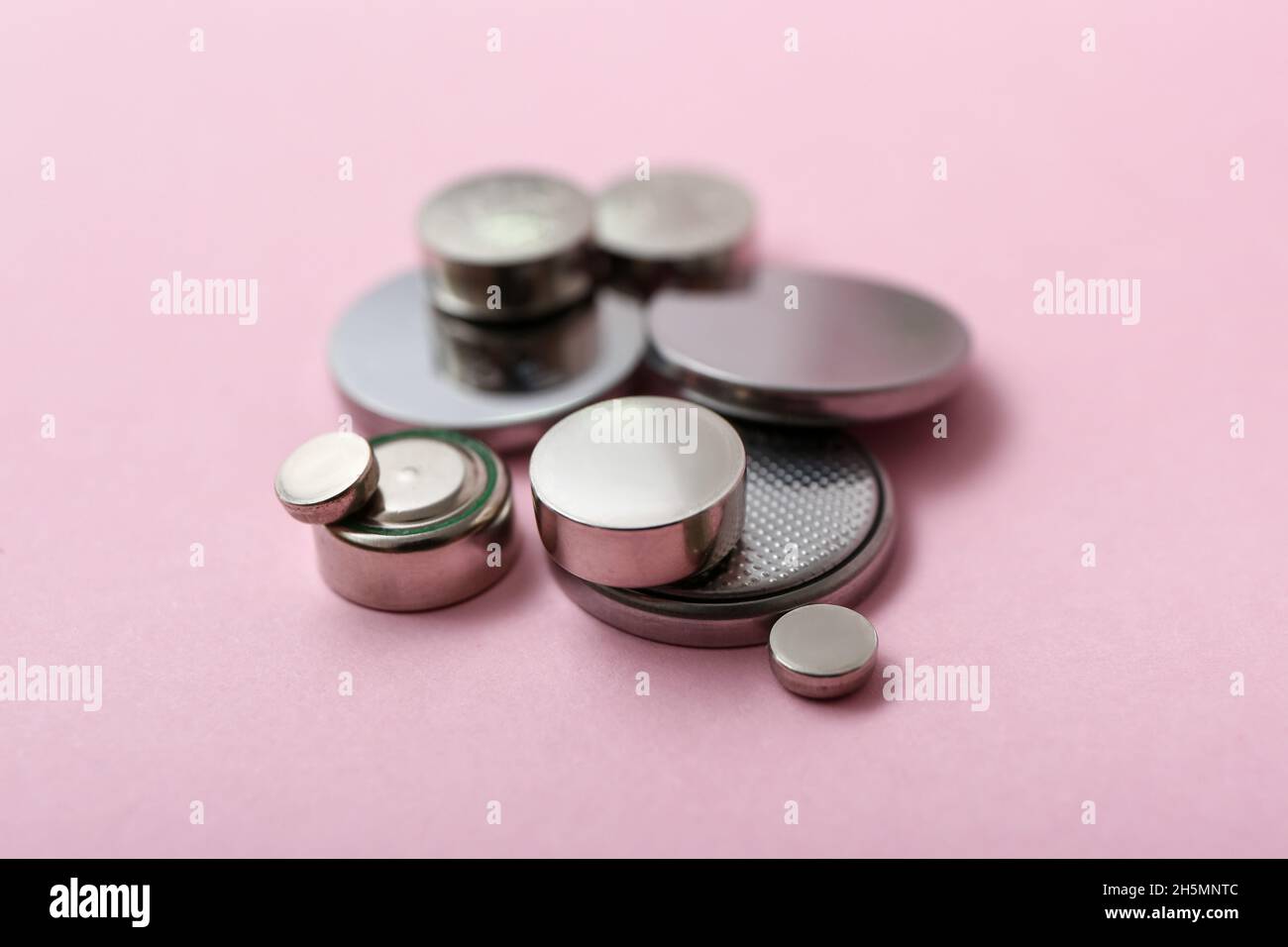 Lithium button cell batteries on pink background Stock Photo - Alamy