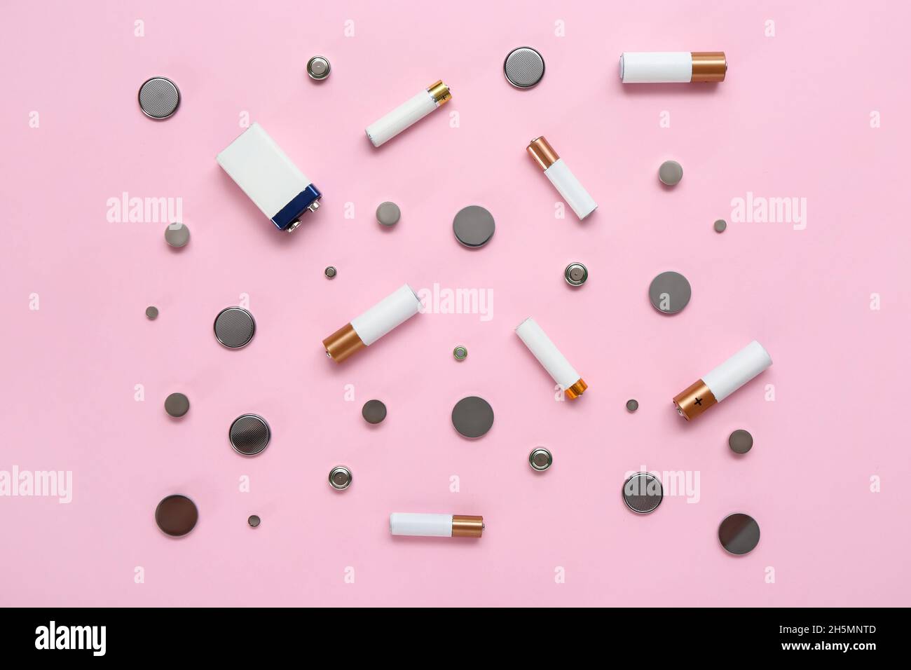 Different batteries on pink background Stock Photo - Alamy